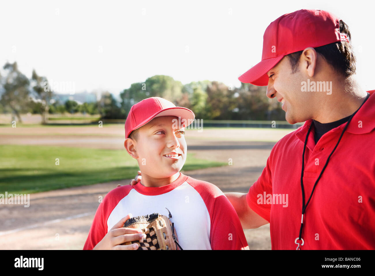 Hispanic baseball player and coach talking Stock Photo - Alamy