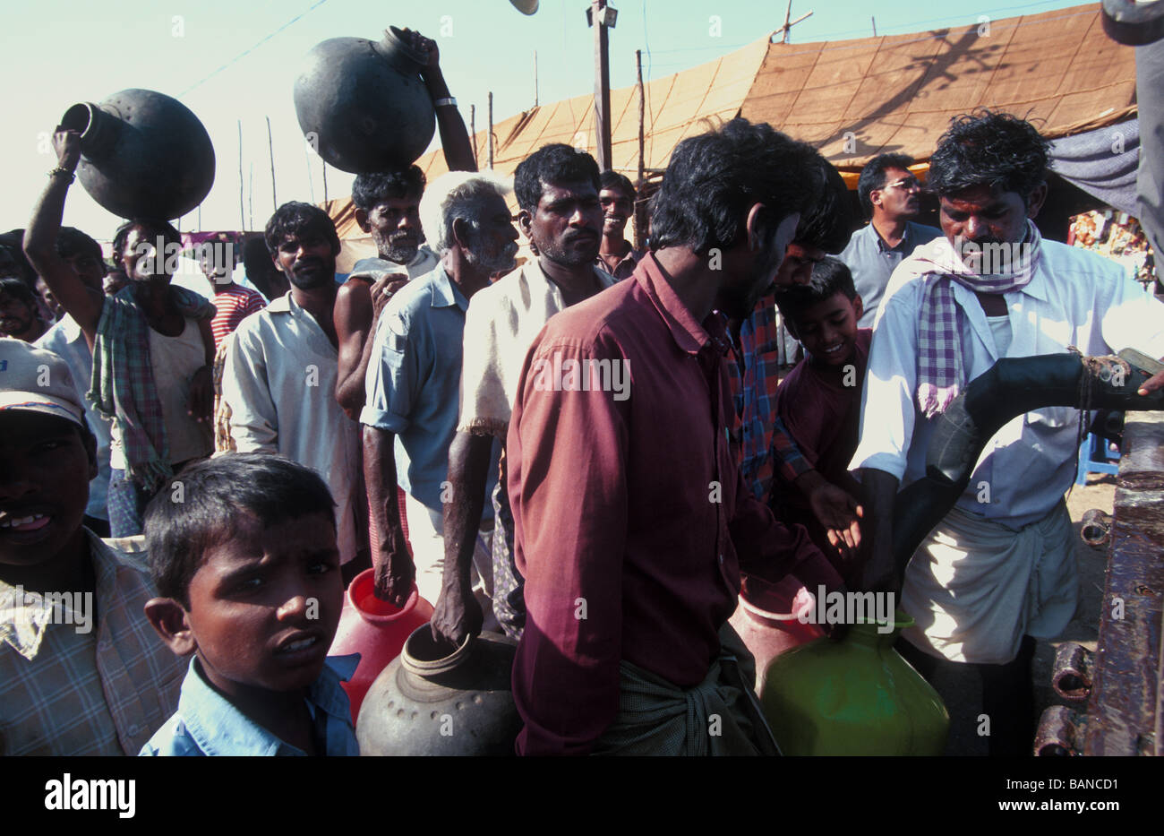 Indian men collecting water hi-res stock photography and images - Alamy