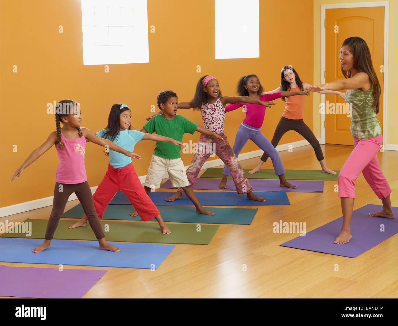 Teacher leading class of children in exercise routine Stock Photo - Alamy