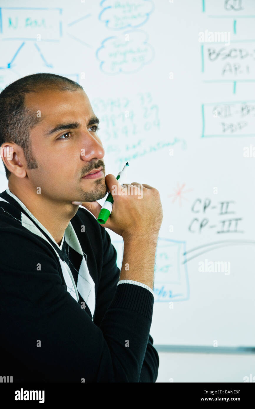Middle Eastern man thinking near whiteboard Stock Photo - Alamy