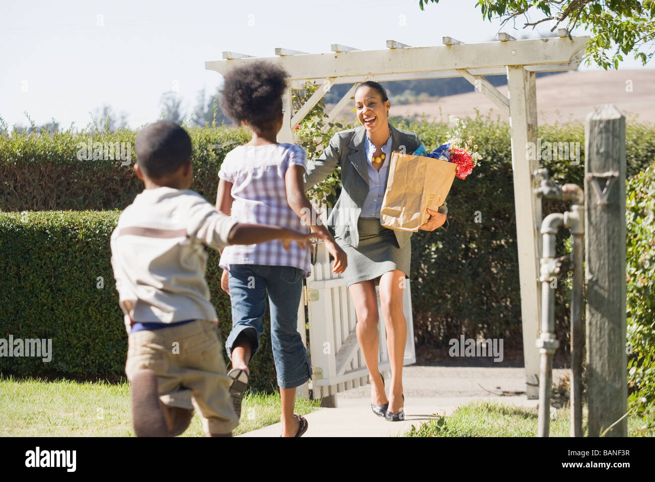 Children running to mother carry groceries Stock Photo - Alamy