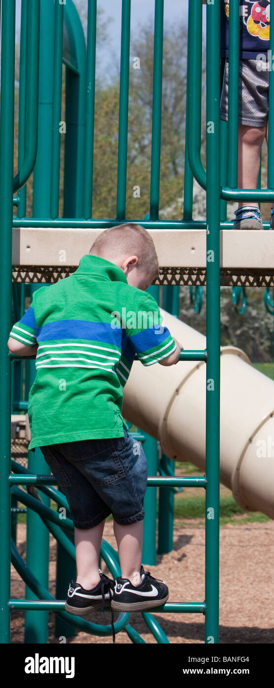 A young child climbing climbing on a playground playset Stock Photo - Alamy