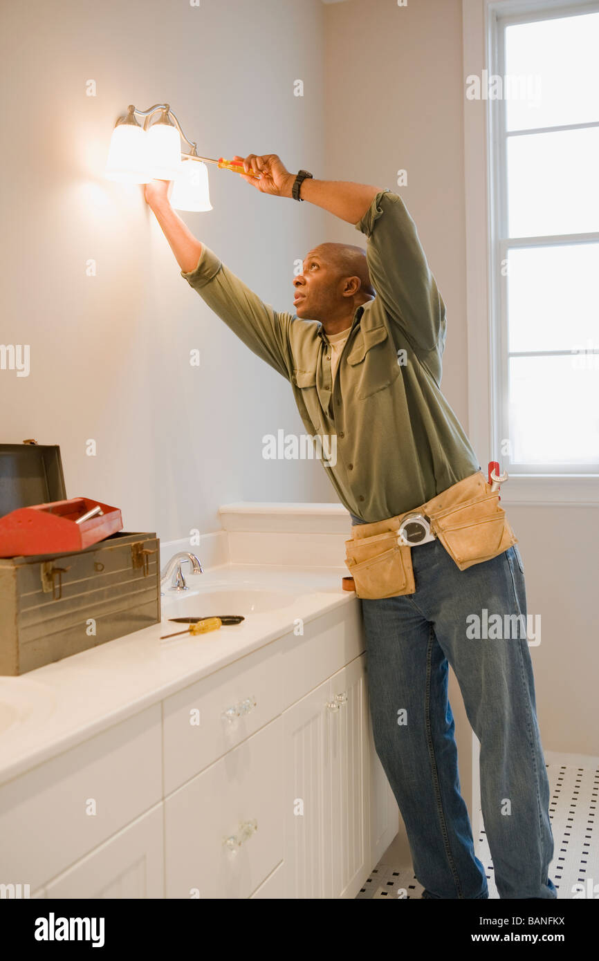 African man repairing light fixture Stock Photo - Alamy