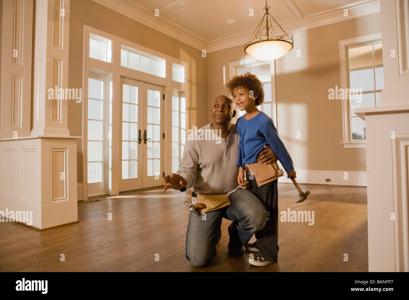 African father and son wearing tool belts Stock Photo - Alamy