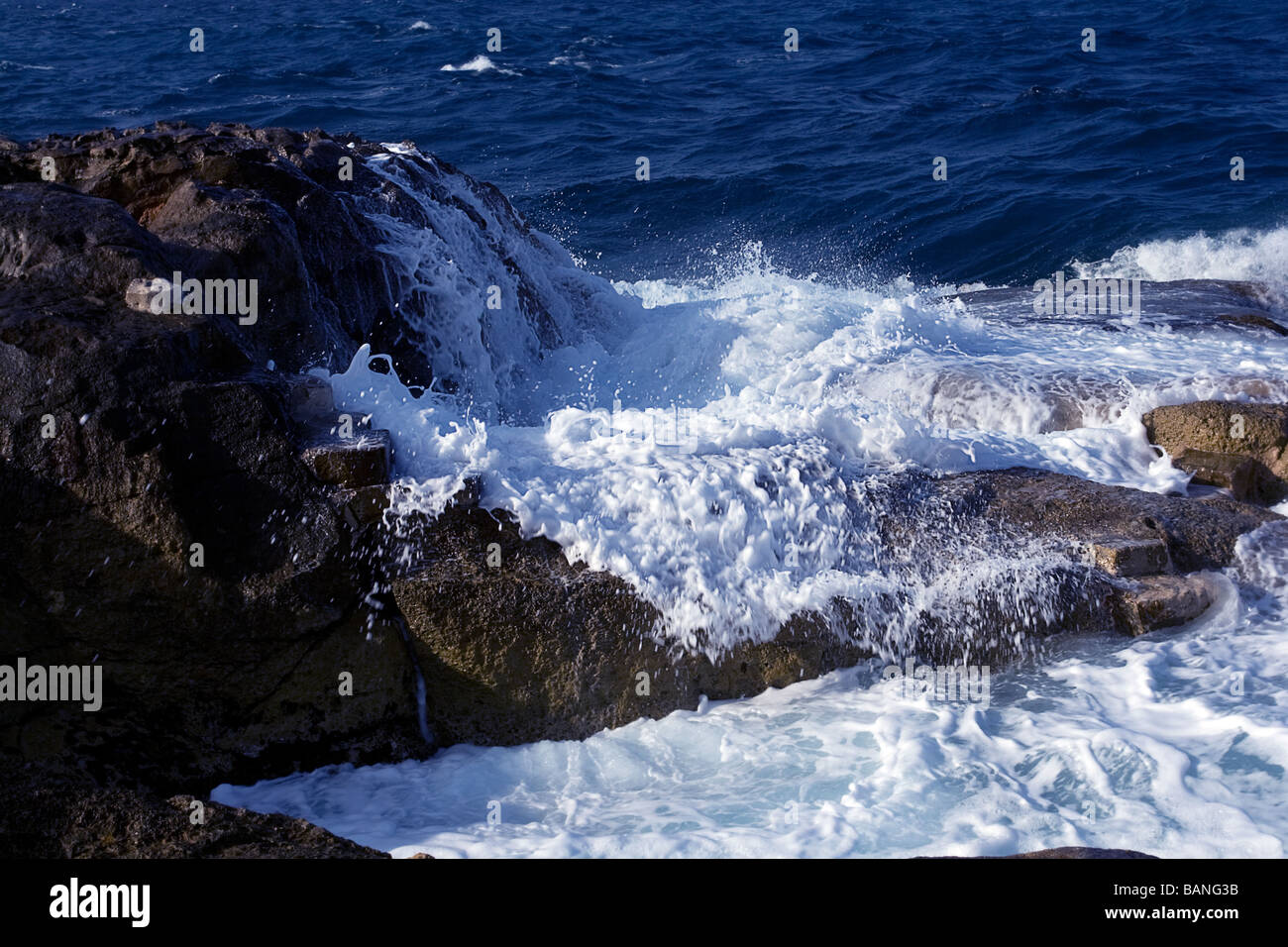Waves and surf splashing against rocks Stock Photo - Alamy