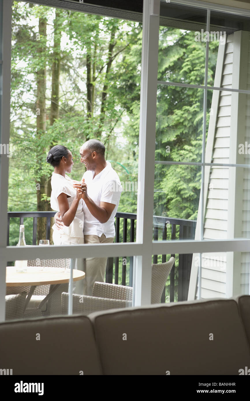 View through window to couple dancing on deck Stock Photo - Alamy