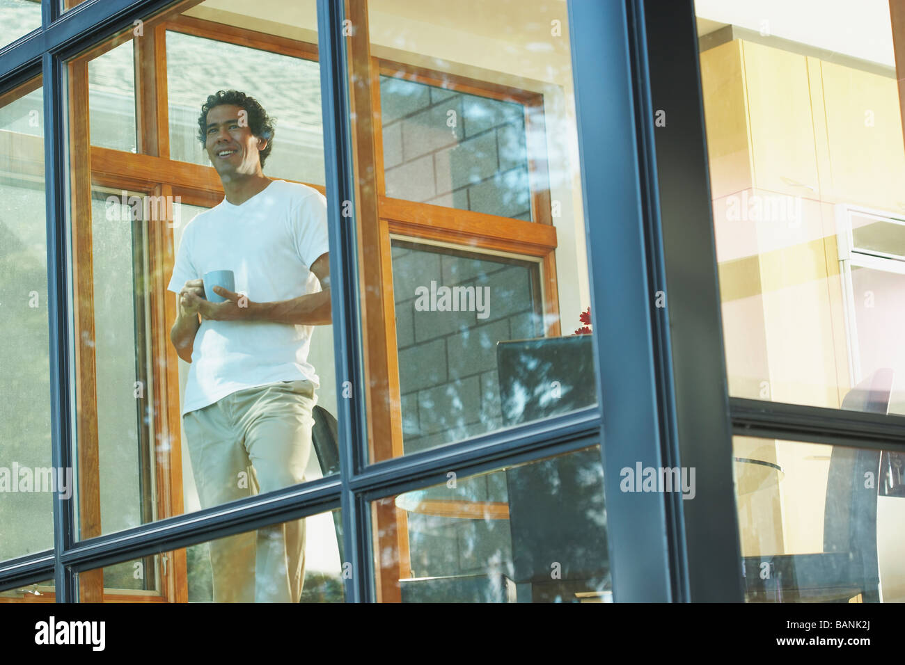 Man looking through window Stock Photo - Alamy
