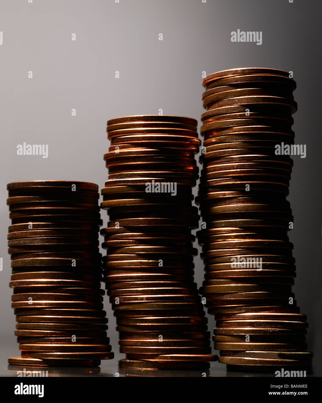 Three stacks of pennies on grey background with highlight on left Stock ...
