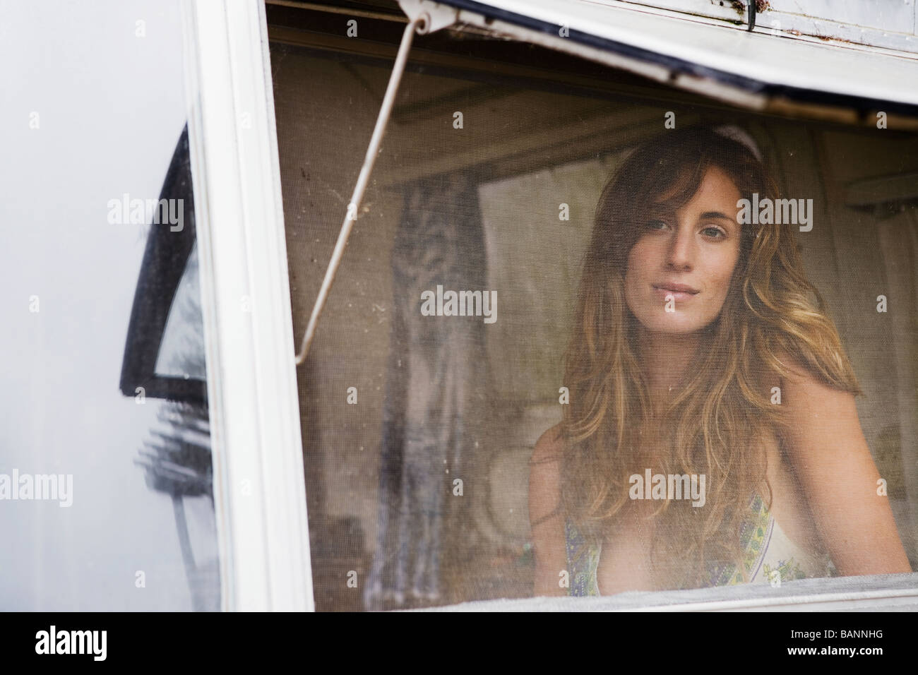 Mixed race woman looking through screen Stock Photo - Alamy