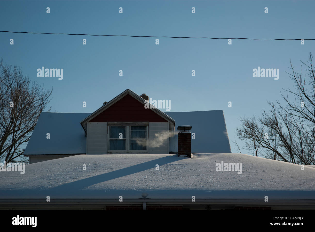 Smoke rises from a chimney atop a two story house in Indiana Stock ...