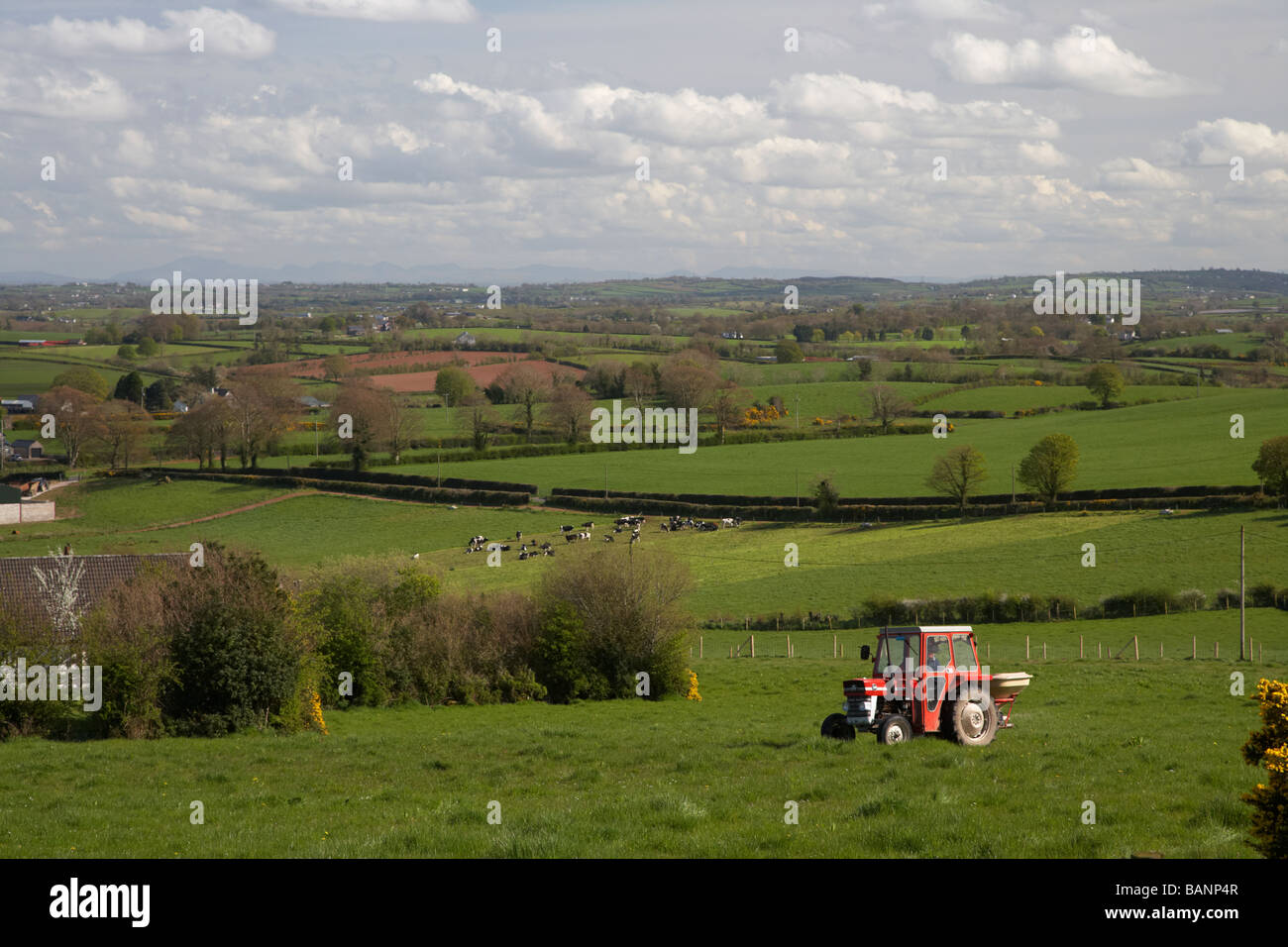 farmer on a tractor spreading fertilizer on fields in the rural ...