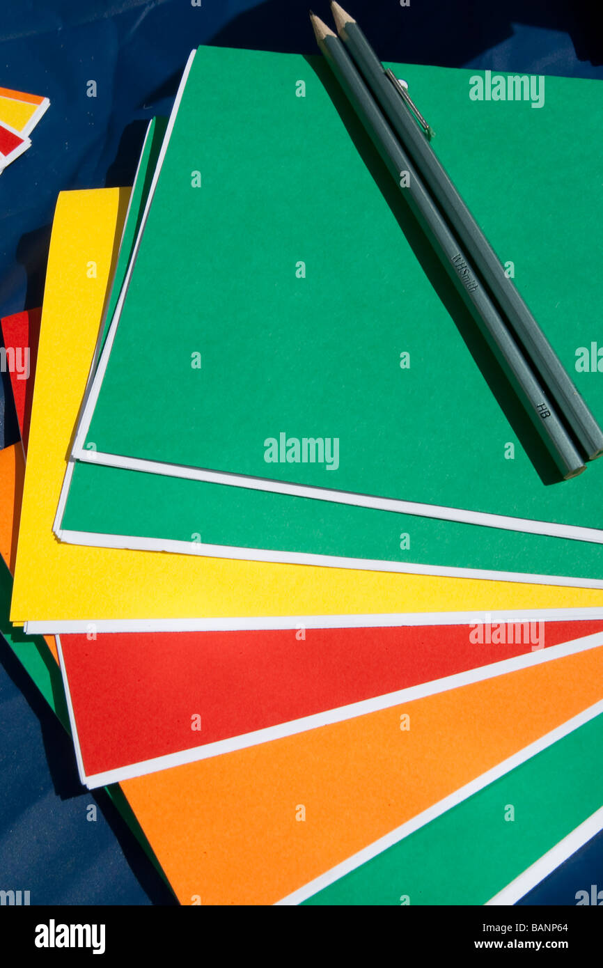 Brightly coloured school childrens exercise books and pencils on a ...