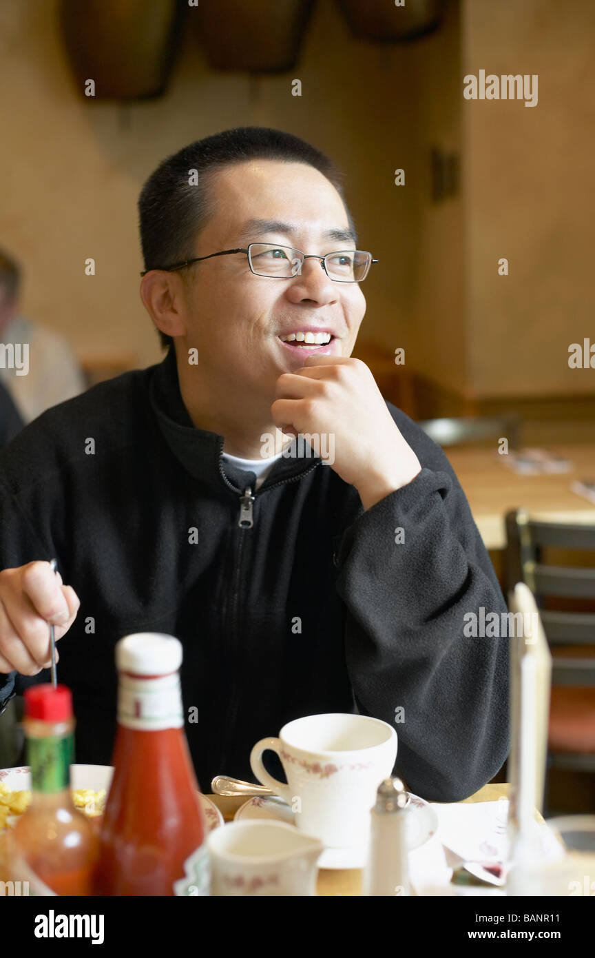 Asian man eating in restaurant Stock Photo - Alamy