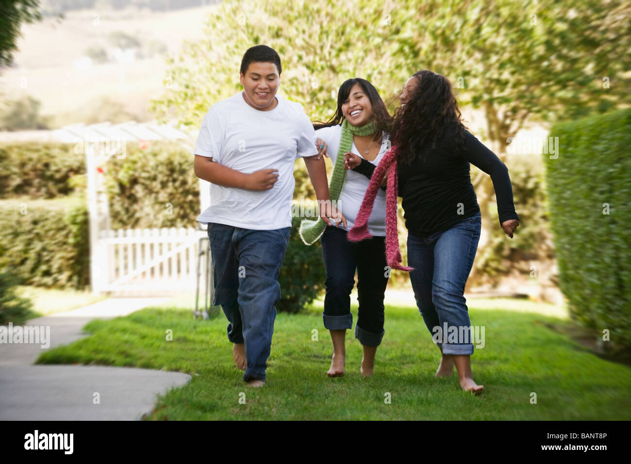 Hispanic siblings running on grass Stock Photo - Alamy