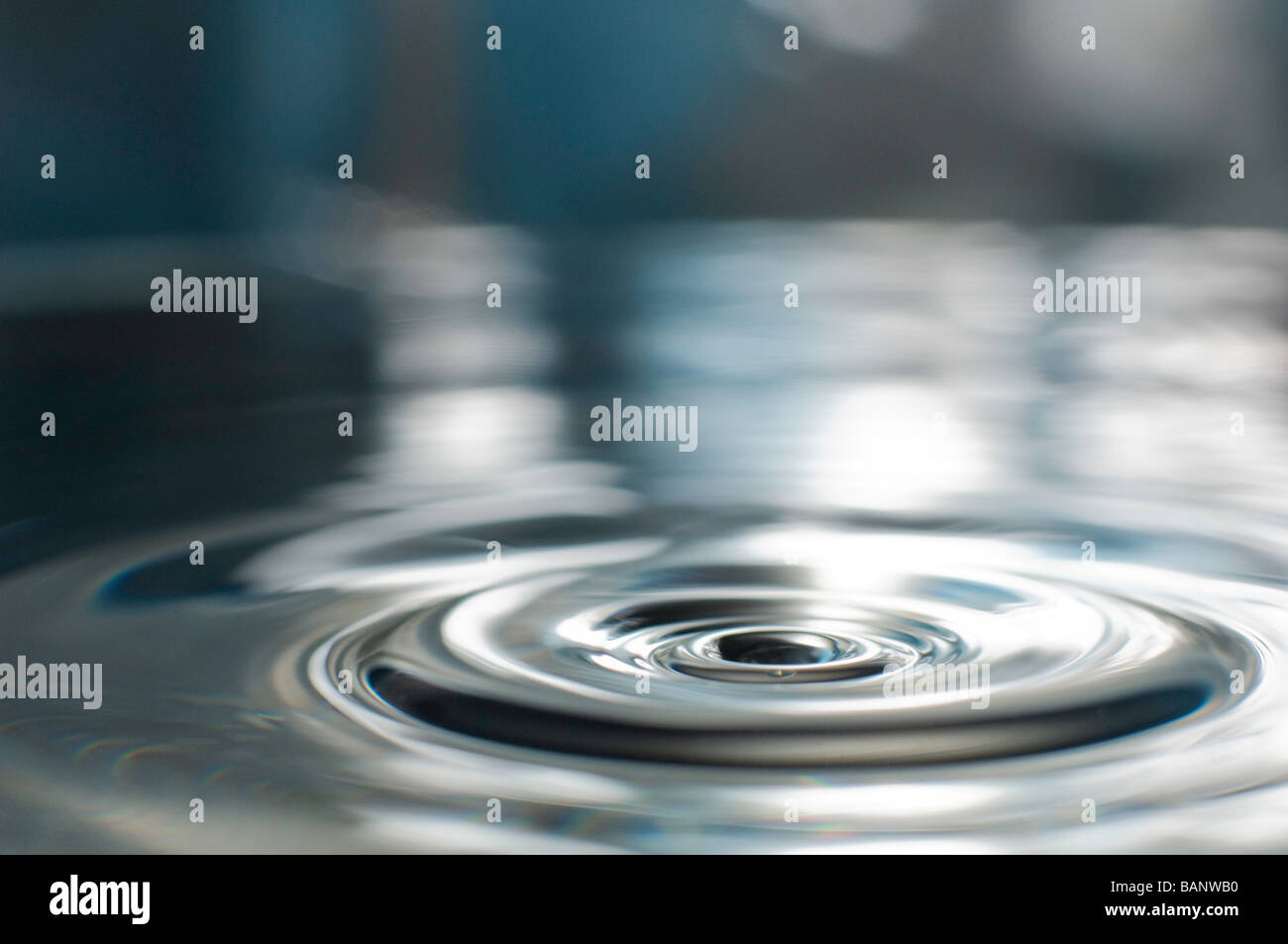 Droplet causing ripples on surface of a pool of water Stock Photo - Alamy