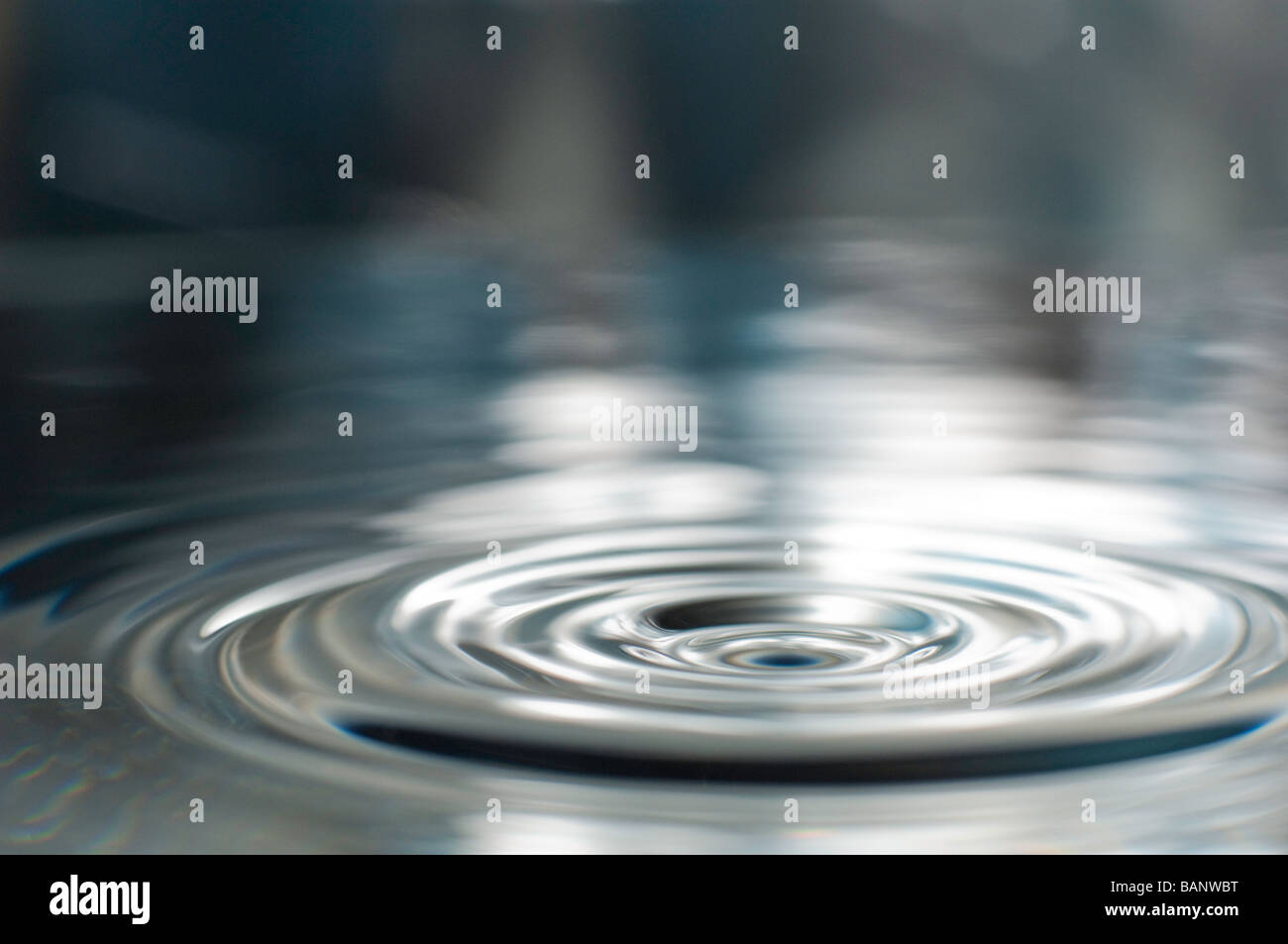 Droplet causing ripples on surface of a pool of water Stock Photo - Alamy