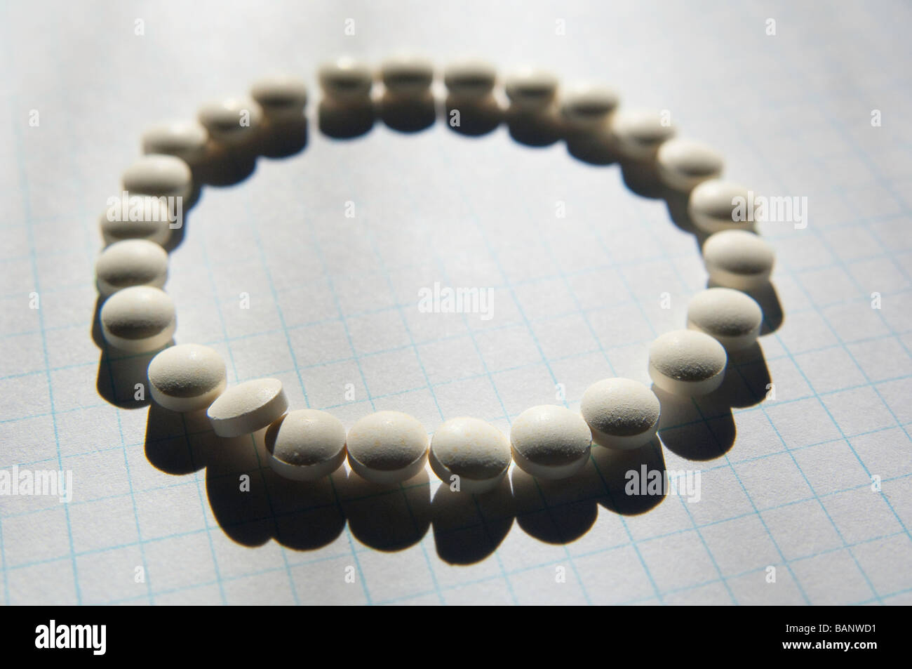 Pills on graph paper aligned to form a circle with one pill leaning on ...