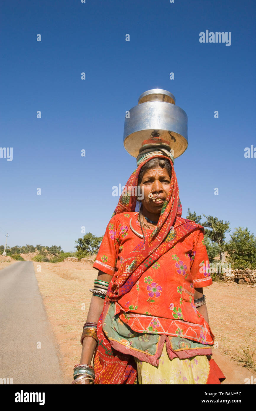 Indian woman walking with pot on head hi-res stock photography and ...