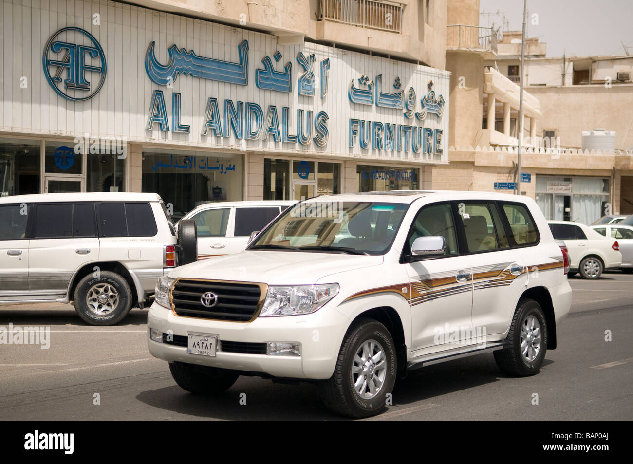 Toyota 4x4 driving through Doha old quarter with Arabic furniture shop ...