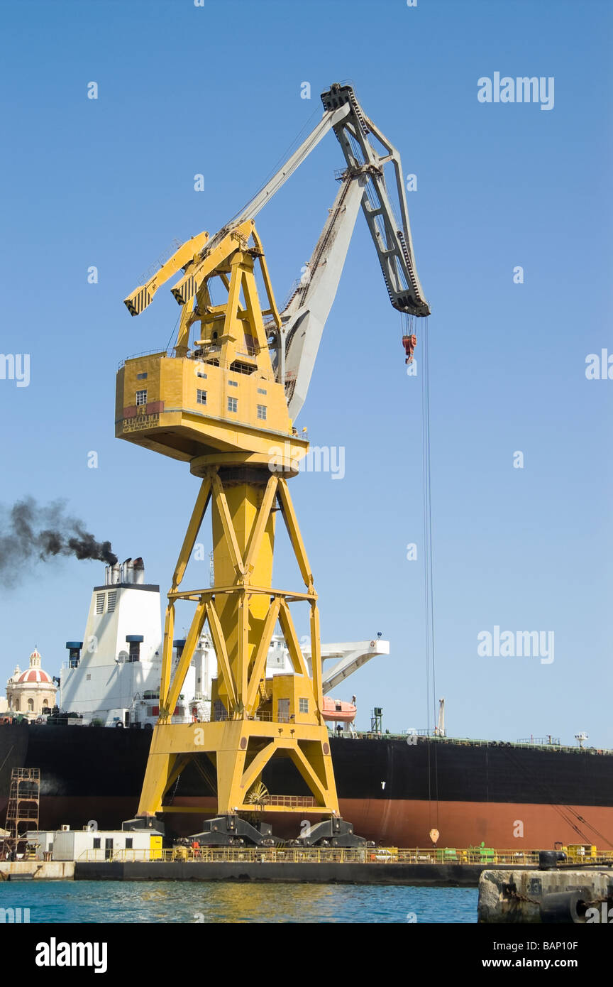 Yellow crane and ship in harbour or dry dock Stock Photo - Alamy