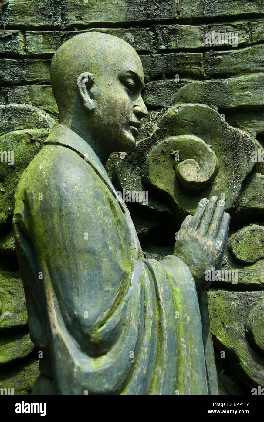 Statue of a praying Buddhist monk at the Mount Emei Shan National Park ...