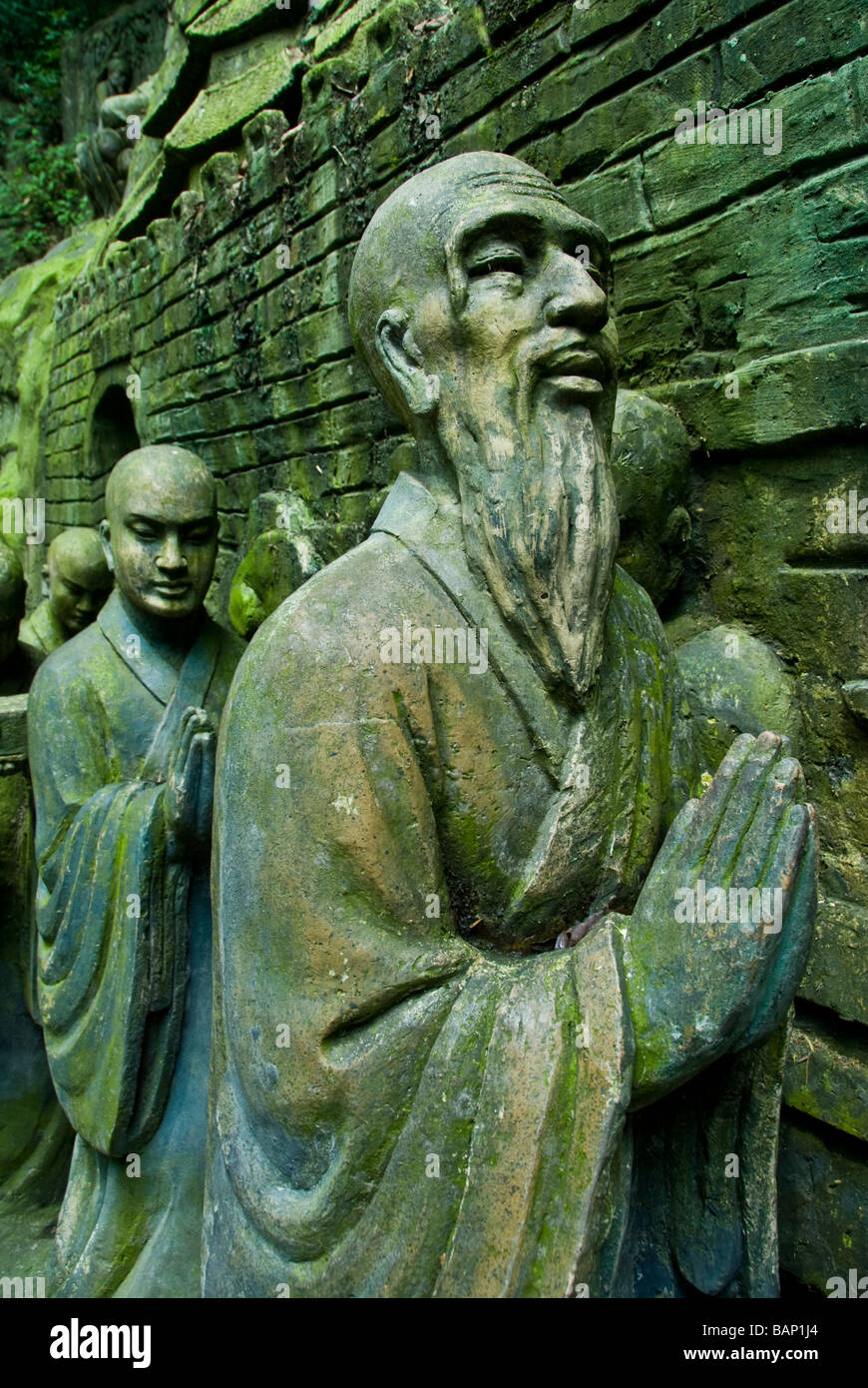 Statue of a praying Buddhist monk at the Mount Emei Shan National Park ...