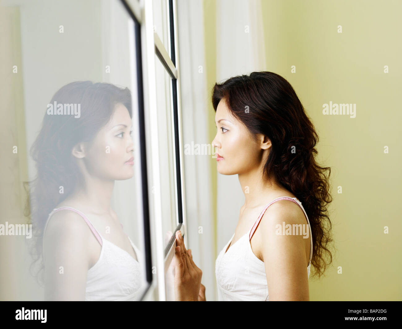 woman standing look through window Stock Photo - Alamy