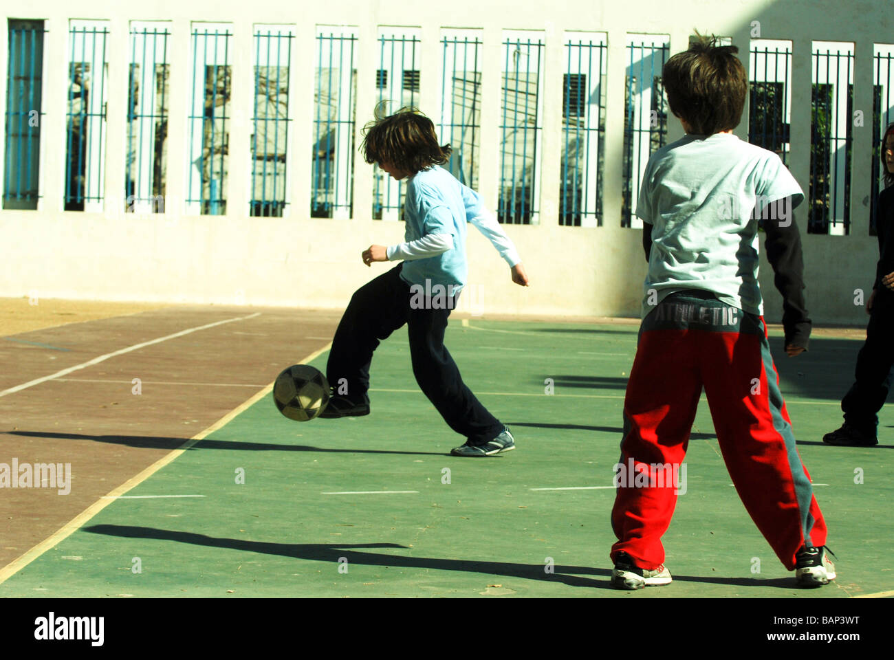 Children playing soccer in a school yard Stock Photo - Alamy
