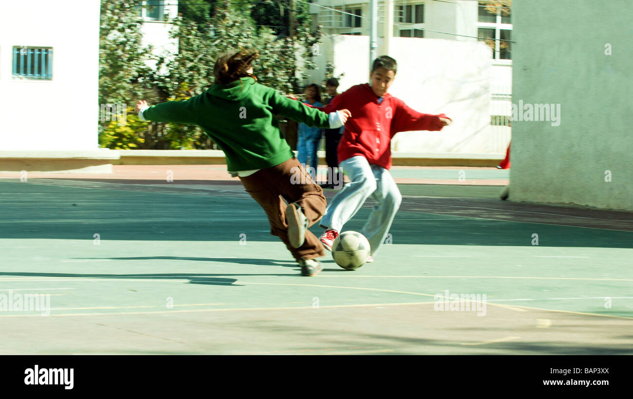 Children playing soccer in a school yard Stock Photo - Alamy