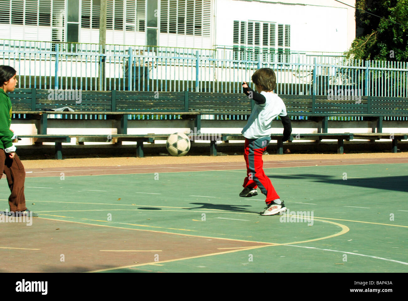 Children playing soccer in a school yard Stock Photo - Alamy
