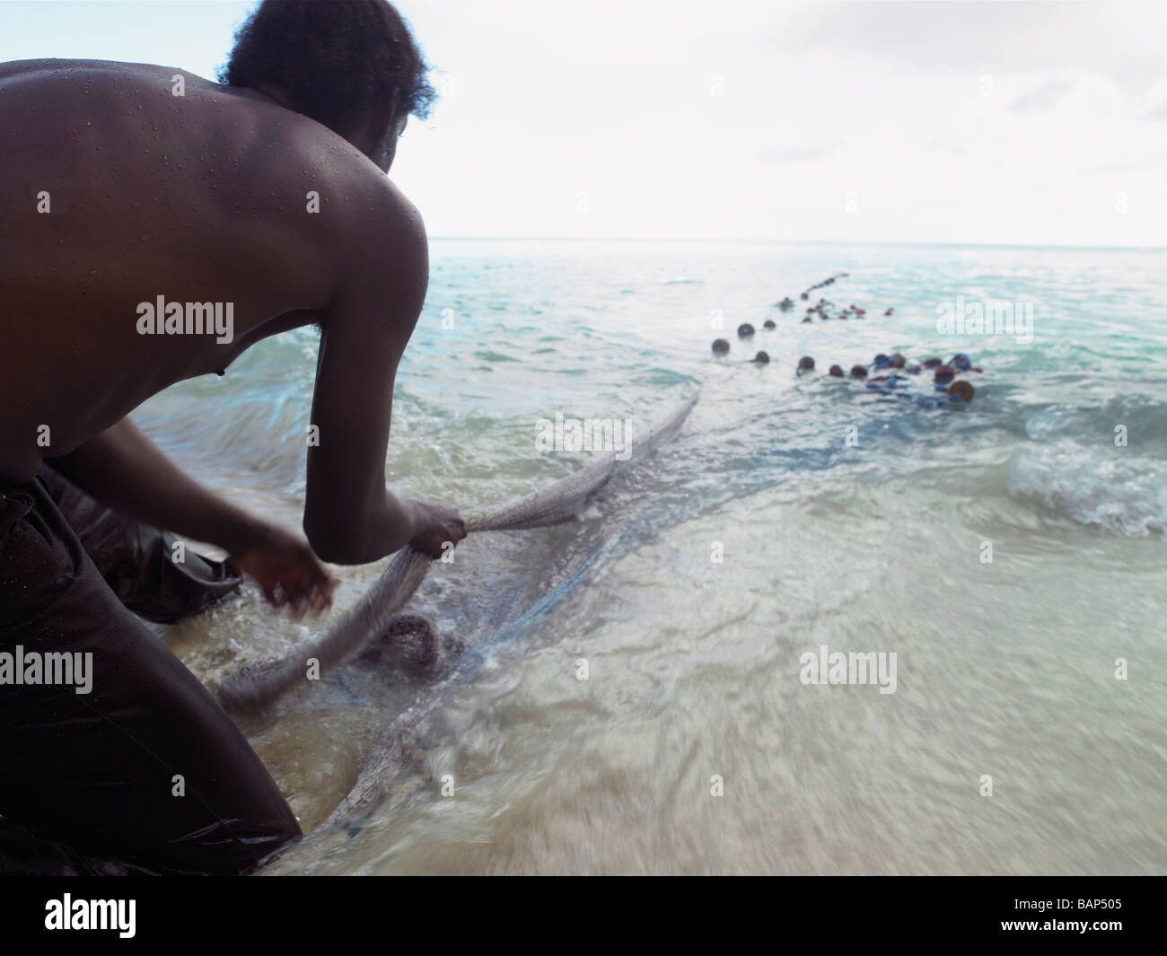 Fisherman pulling net back to shore on Carribean island of Anguila ...