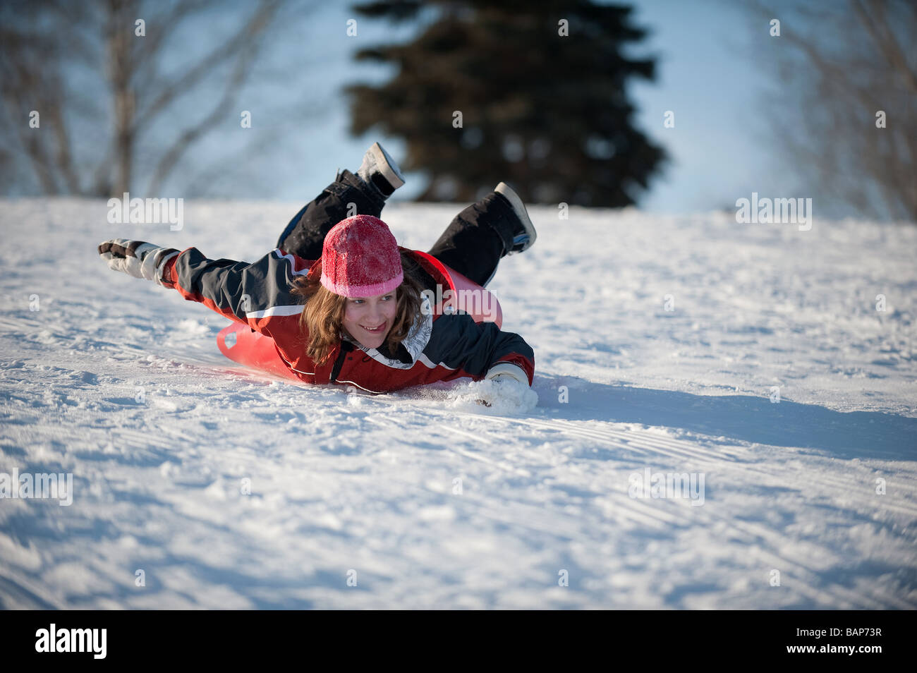Girl sledding down the tobogganing hill Stock Photo - Alamy