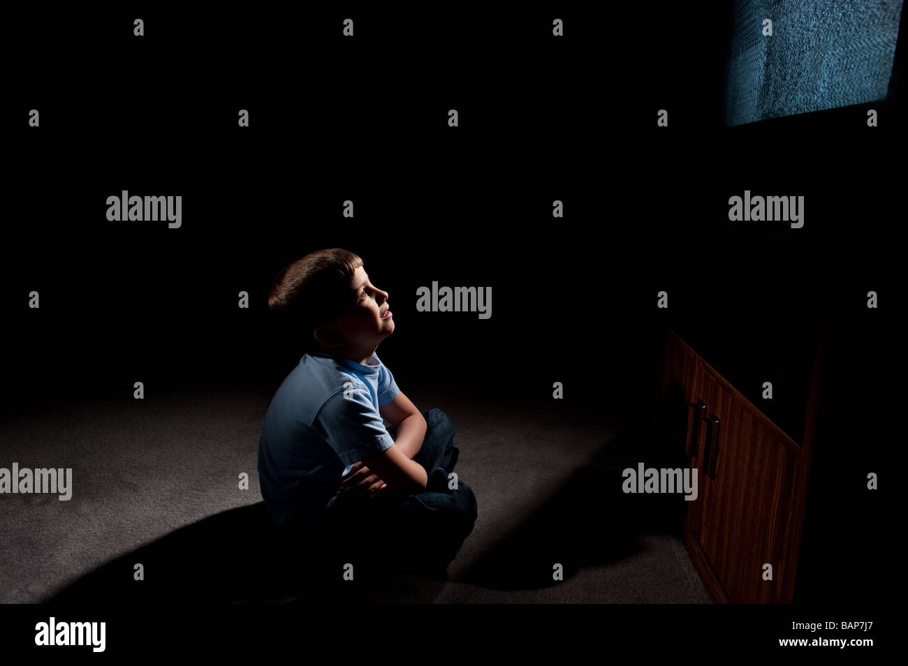 Six year old boy watching static on television in the dark Stock Photo ...
