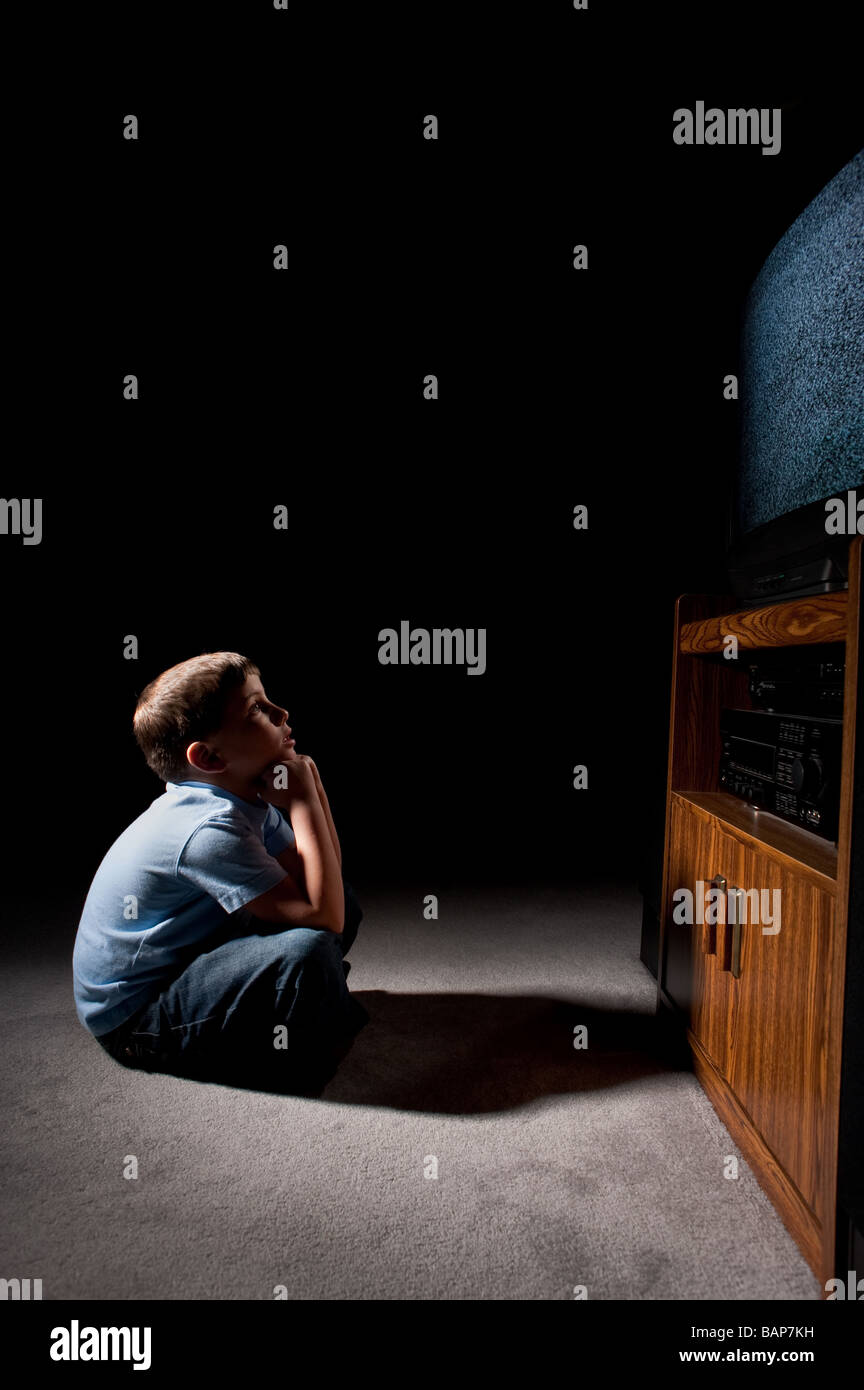 Six year old boy watching static on television in the dark Stock Photo ...
