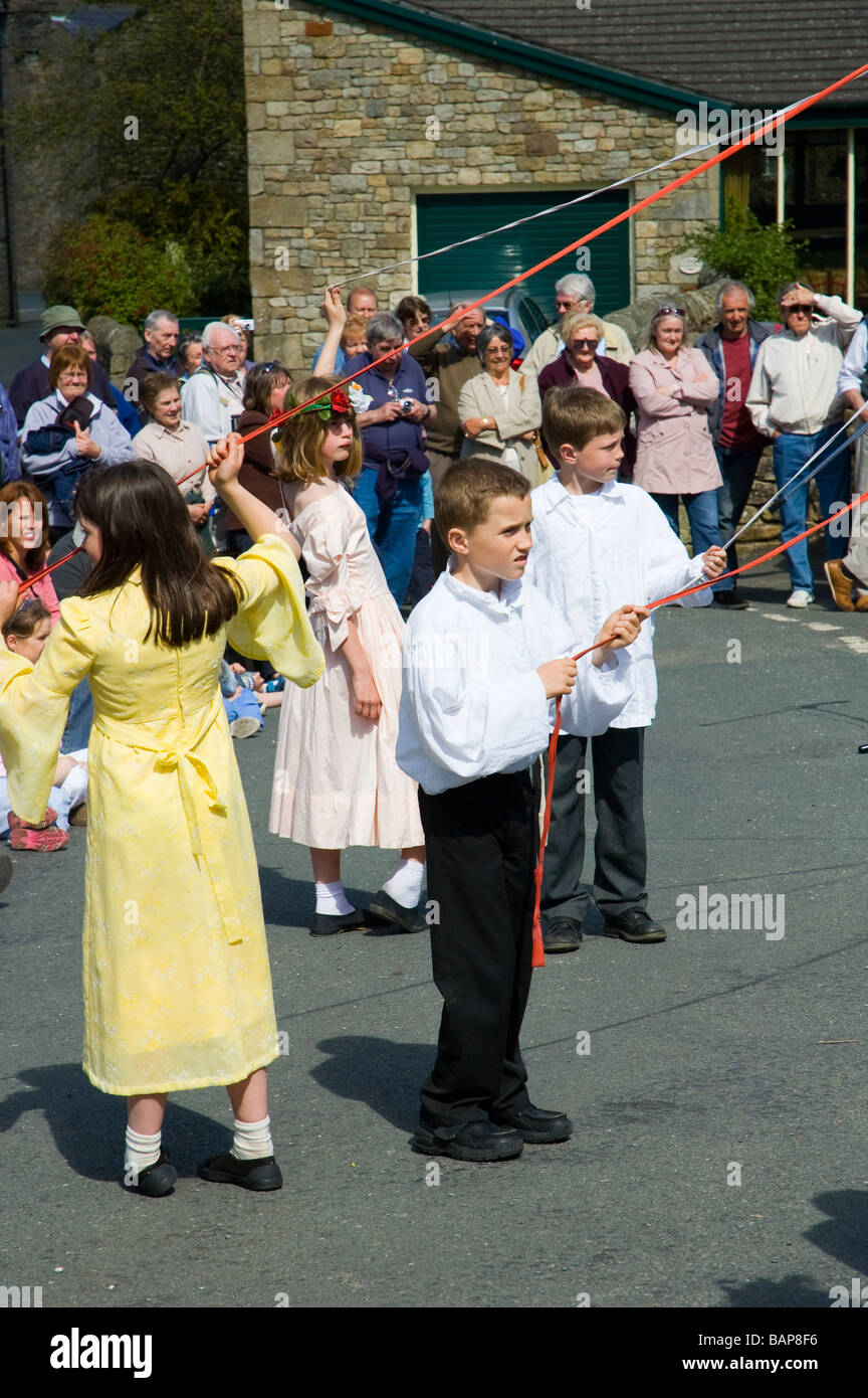 Children dancing around a maypole at the village of Wray, near ...