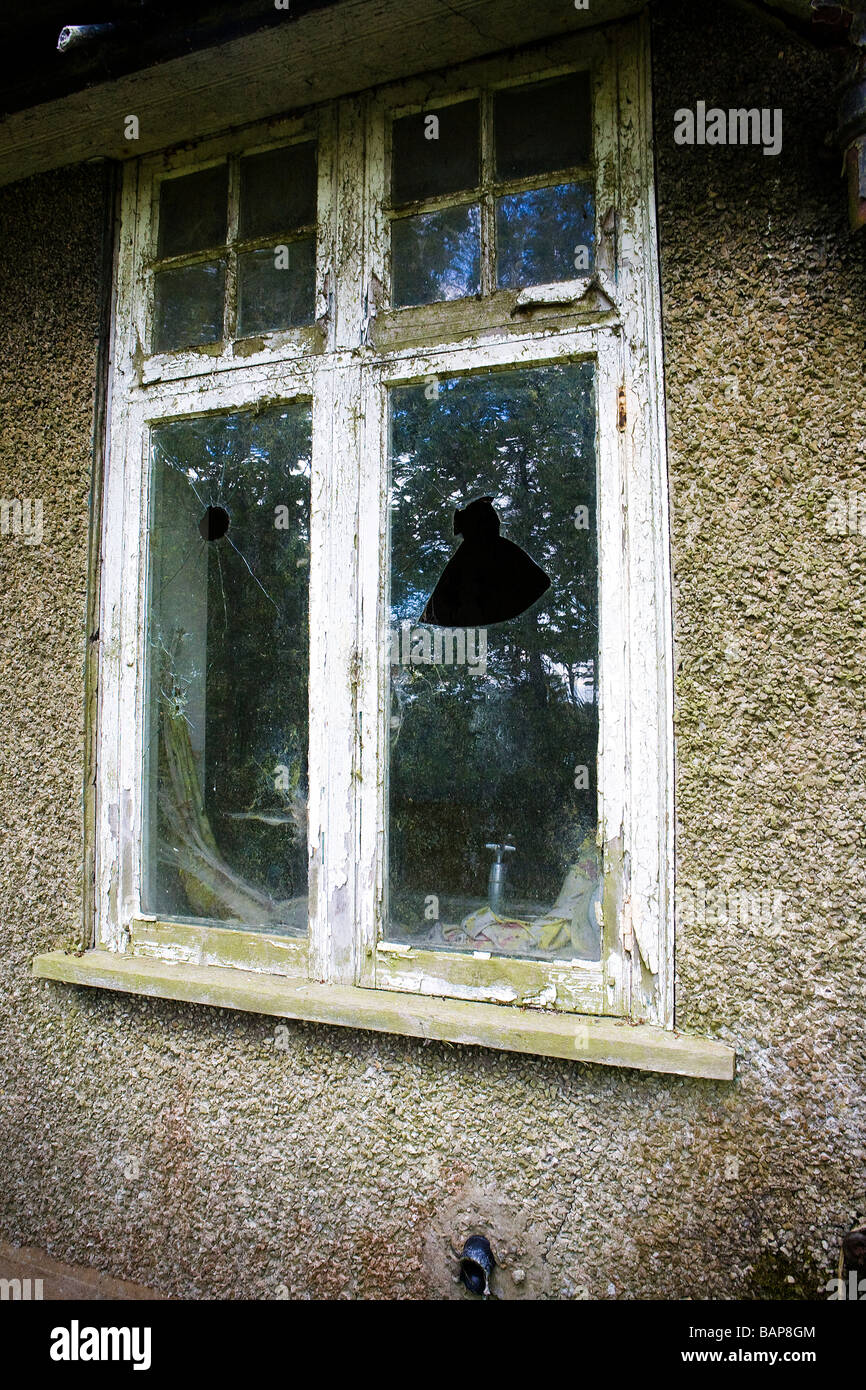 An abandoned cottage lies in disrepair with the glass in the rotten ...