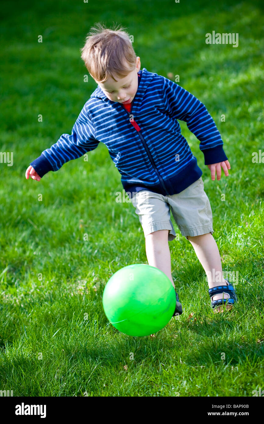 Boy kicking ball Stock Photo - Alamy
