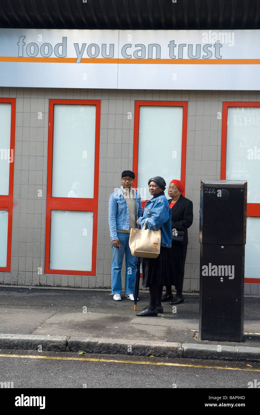 Three women shoppers standing outside a shop with 'Food You Can Trust ...