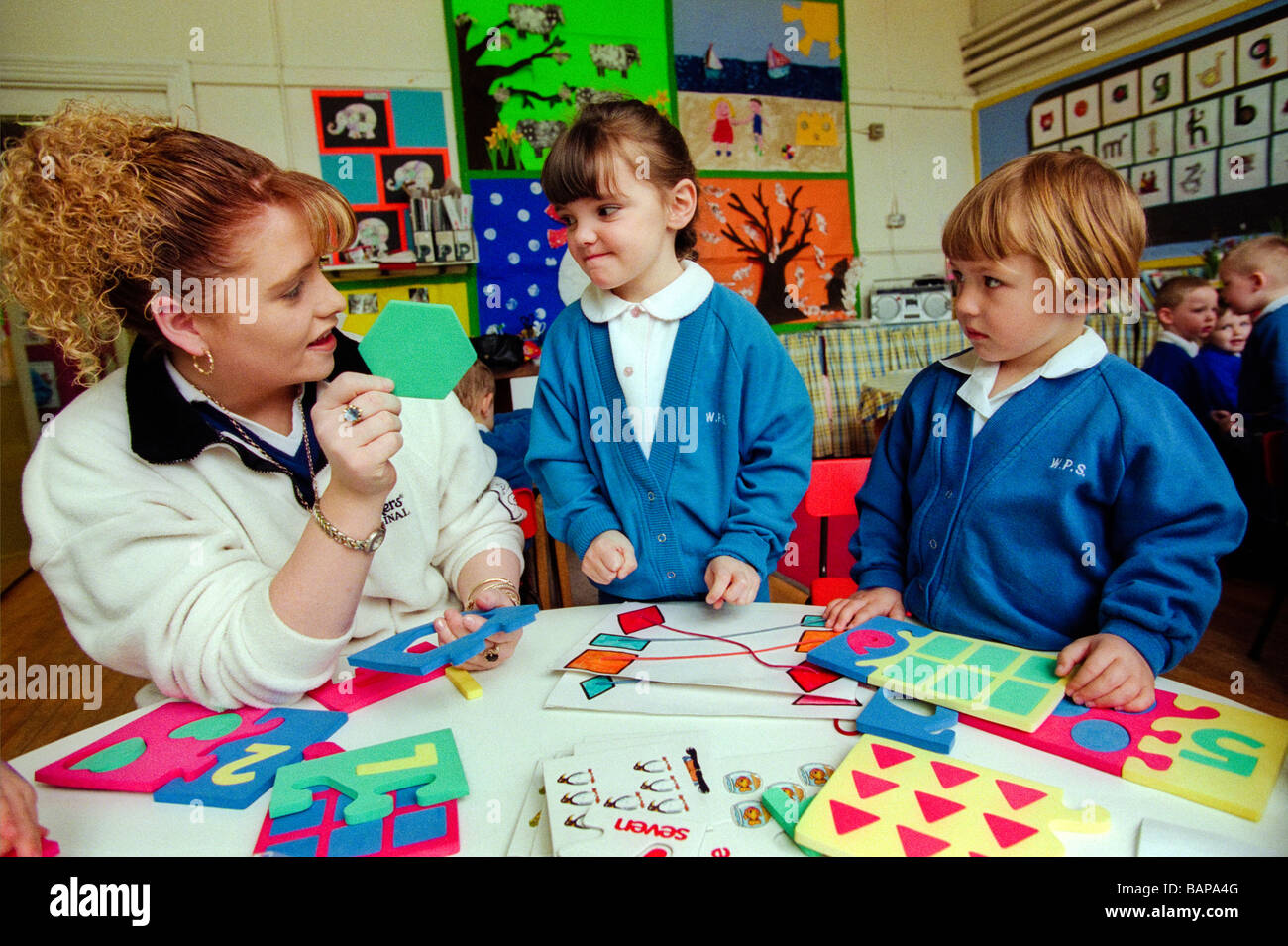 Pupils being taught by teacher in classroom of primary school in the ...