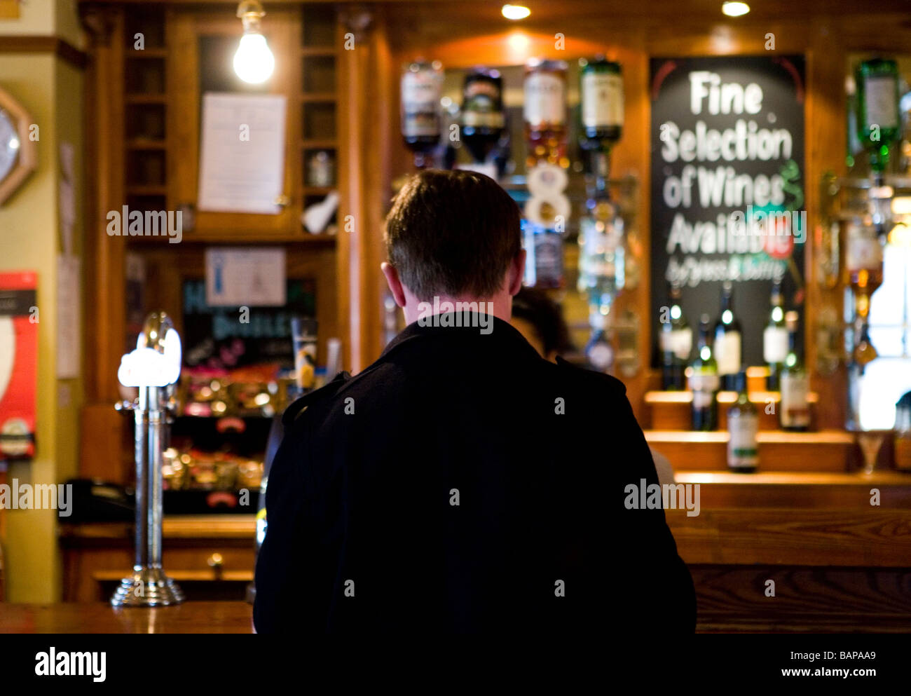 Man sits at the bar of a pub Stock Photo - Alamy