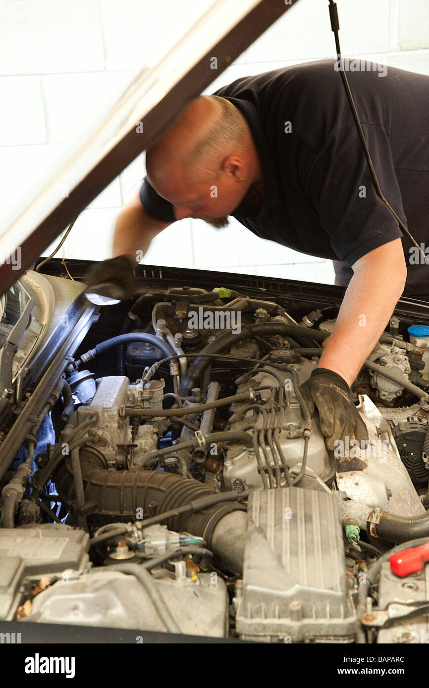 technician checking under the hood / bonnet of a car during an MOT check / service Stock Photo ...