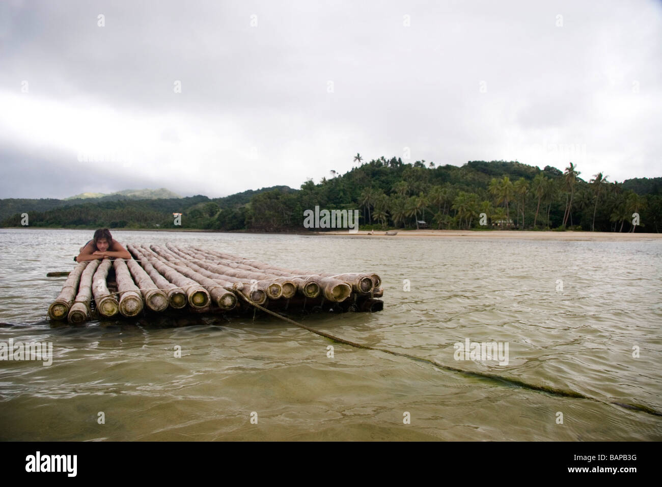 Man lying on bamboo raft in Fiji Stock Photo - Alamy
