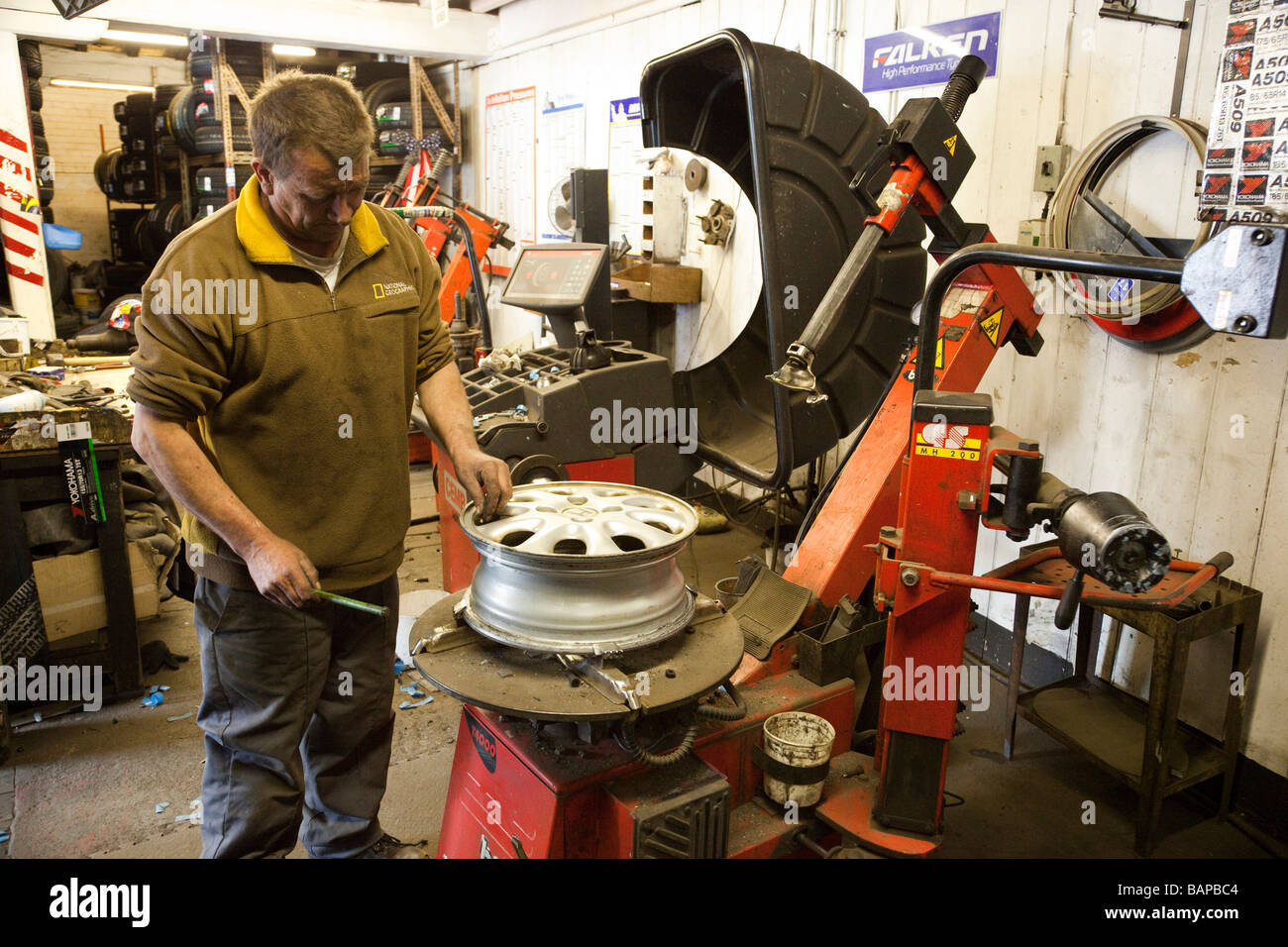 man fitting new tyre on wheel Stock Photo - Alamy