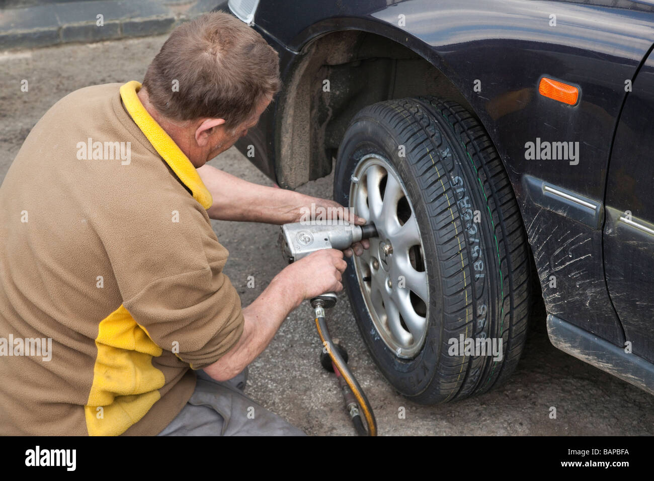 Man fitting new tyre hi-res stock photography and images - Alamy