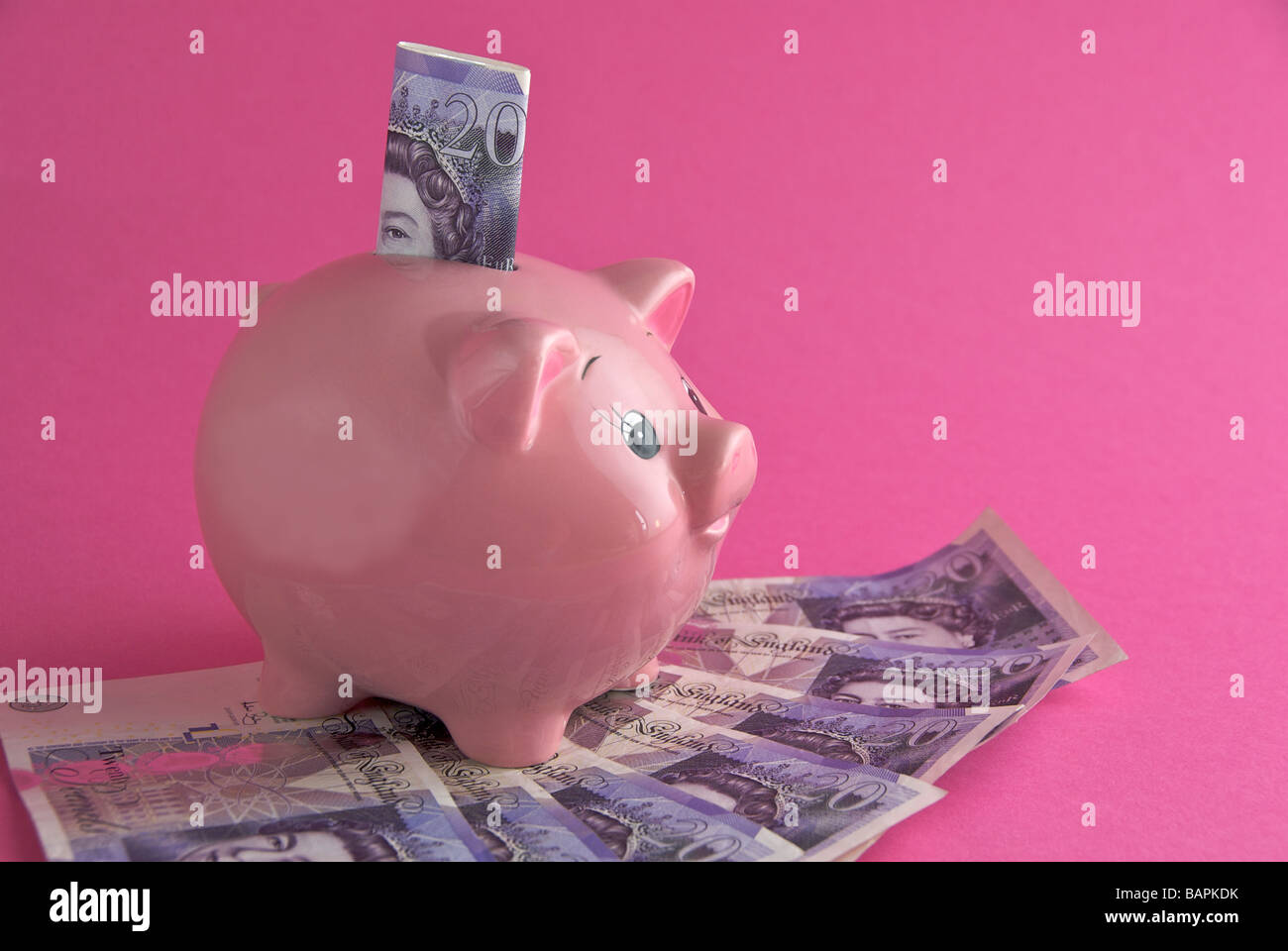 Pink piggy bank and £20 pound notes Stock Photo - Alamy