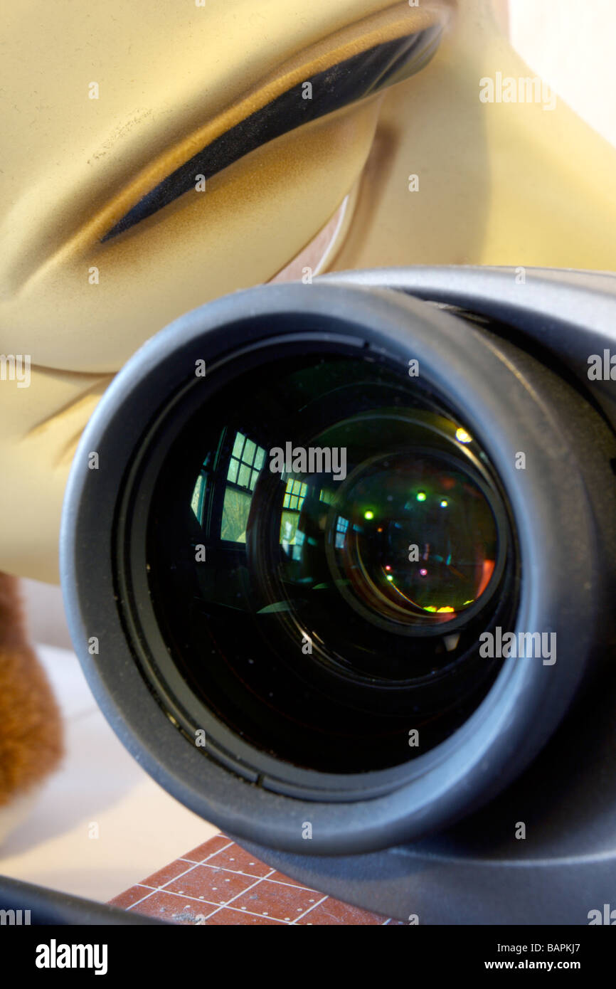 The focussing lens of an a/v projector, reflecting objects in a room ...