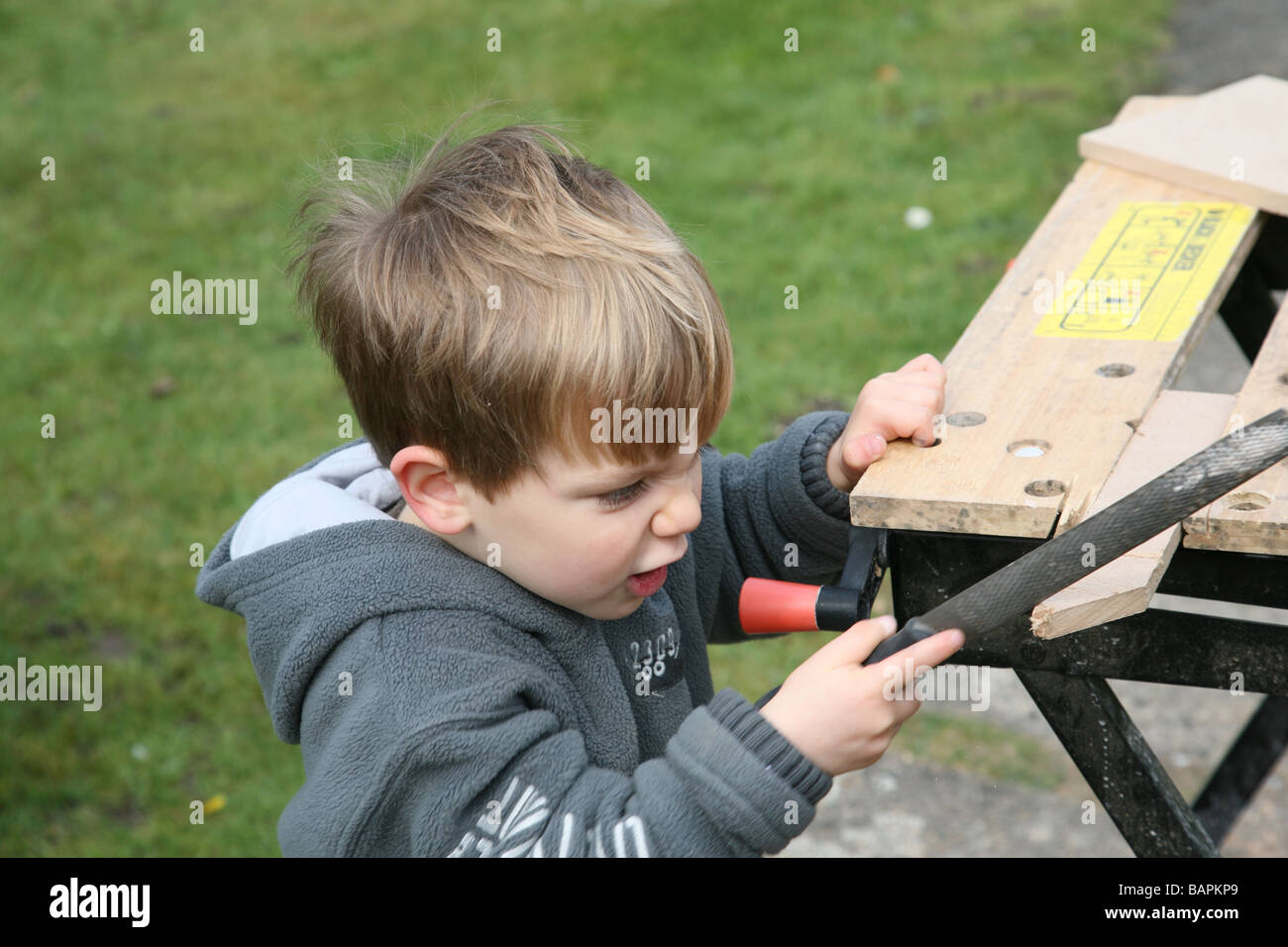 Young boy playing with workbench Stock Photo - Alamy