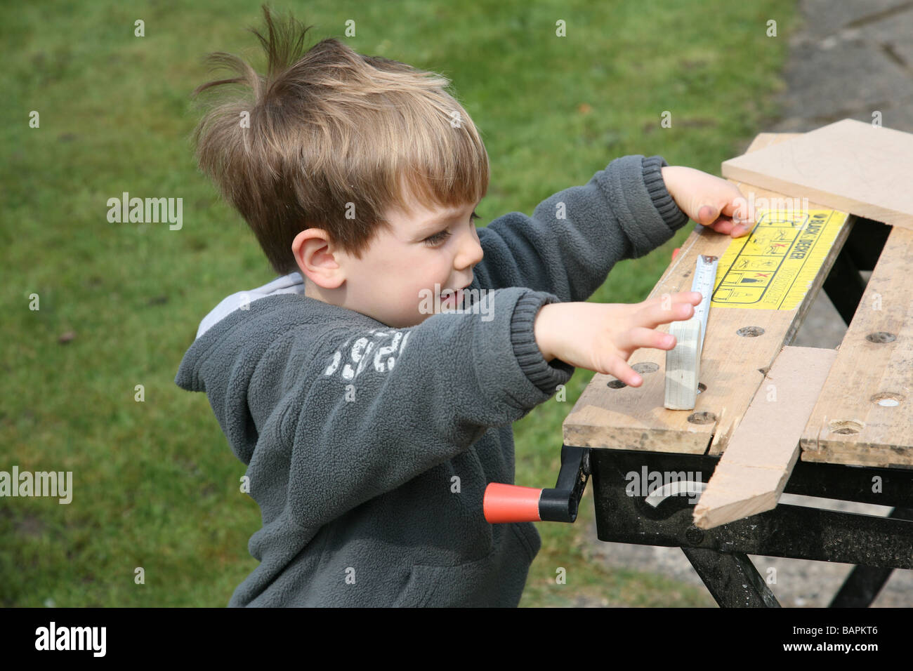 Young boy playing with workbench Stock Photo - Alamy