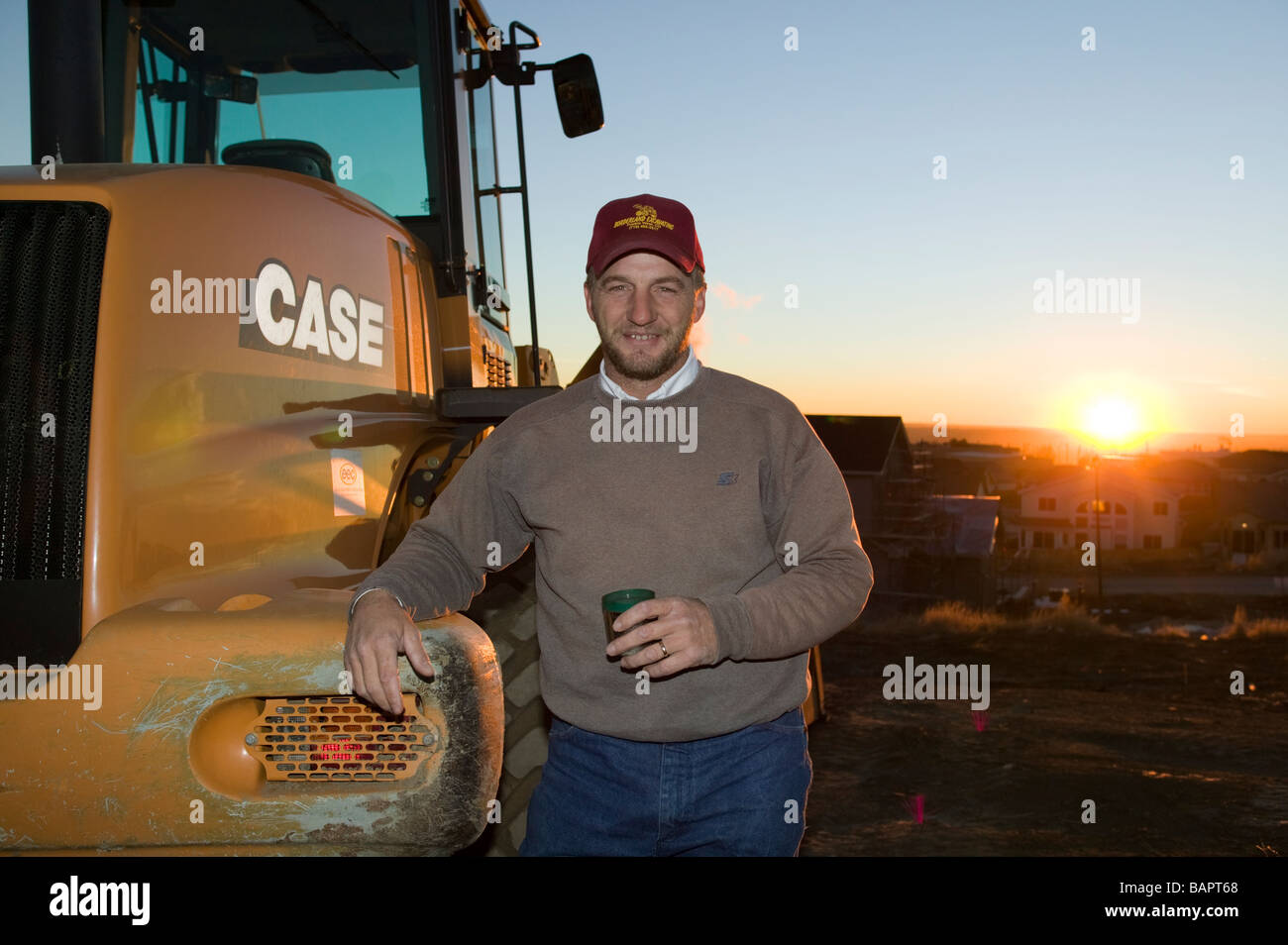 Early morning portrait of small business owner and front end loader ...