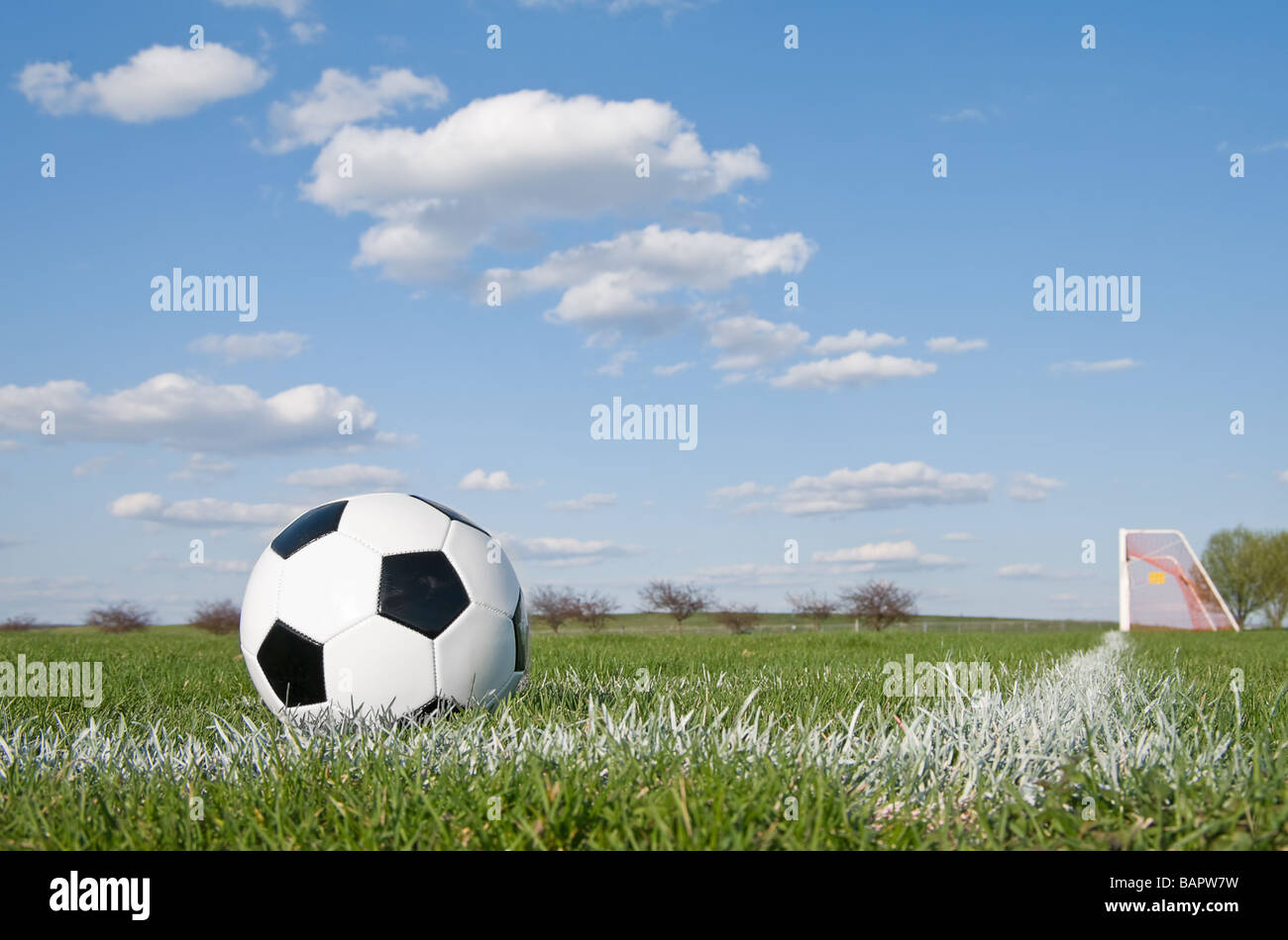 Soccer ball in corner pitch area against blue sky Stock Photo - Alamy